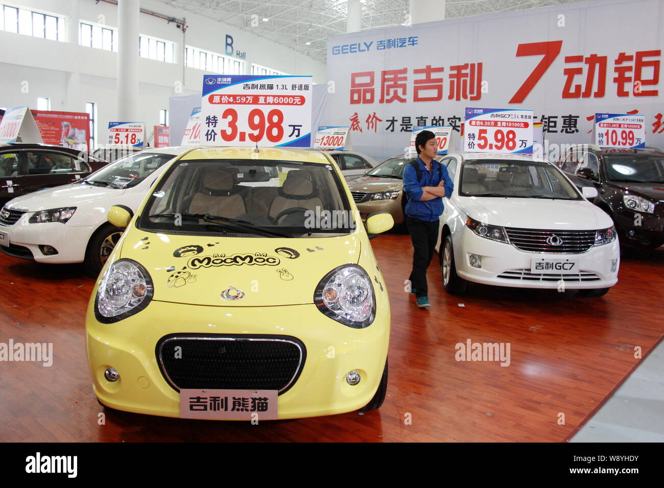 --FILE--A visitor walks past Geely cars on display at an auto show in ...