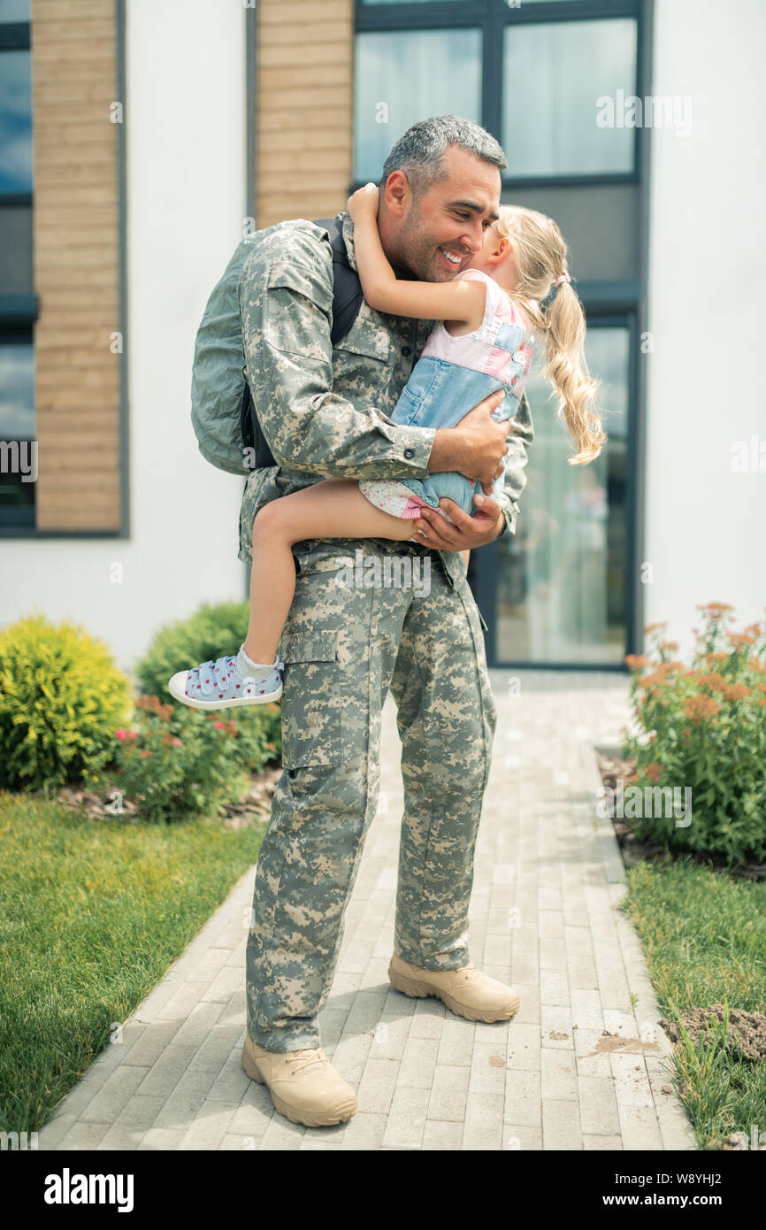 Serviceman feeling emotional while hugging his crying happy daughter ...
