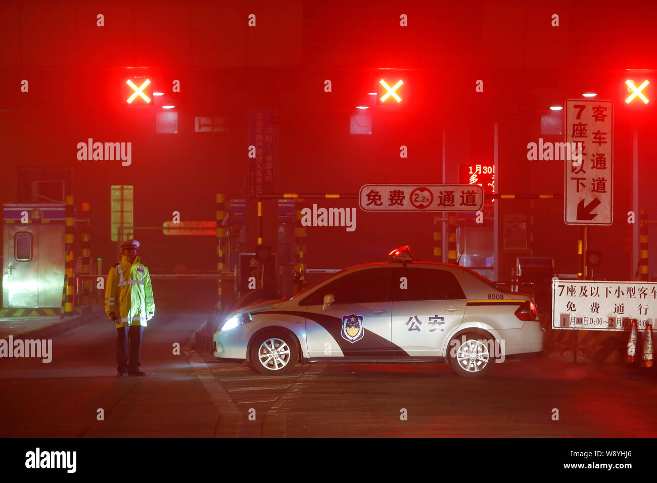 A police officer stands guard at a toll station on an expressway closed ...