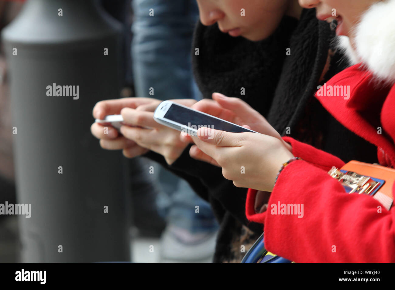 --FILE--Young Chinese women use their smartphones to surf the Internet ...