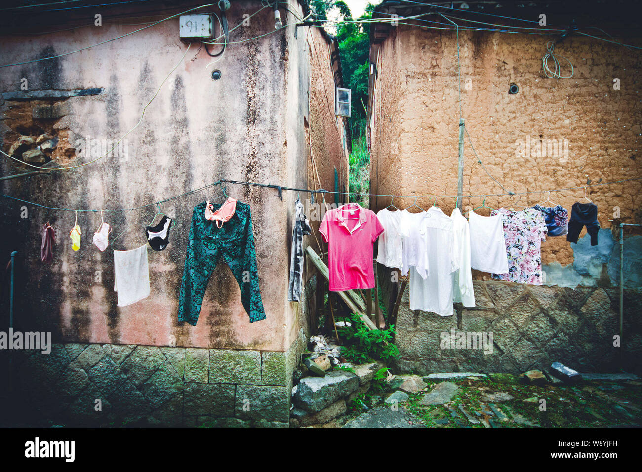 Local Chinese residents use a rope as a makeshift clothesline to hang ...
