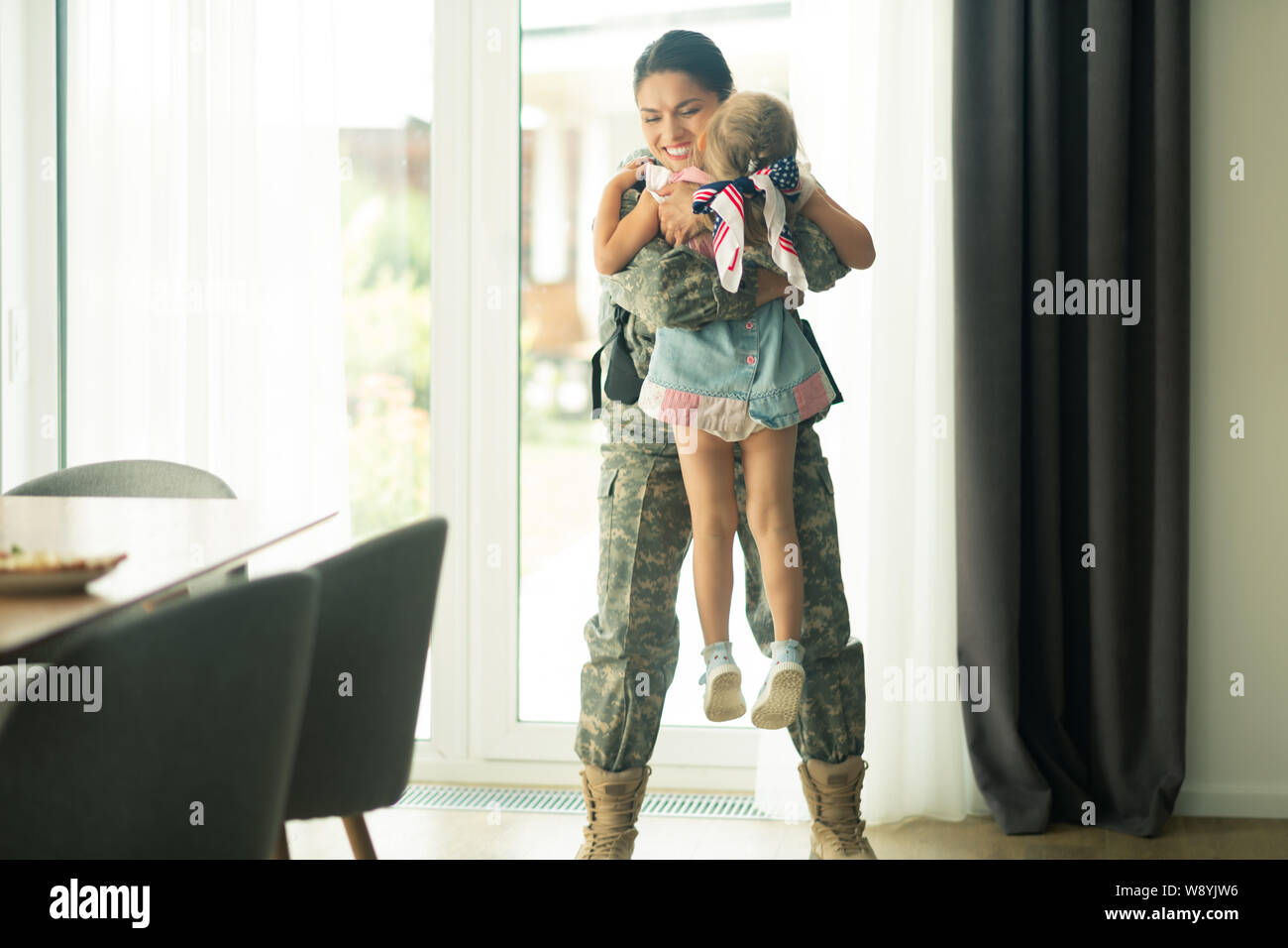 Woman lifting her little daughter while coming back home Stock Photo ...