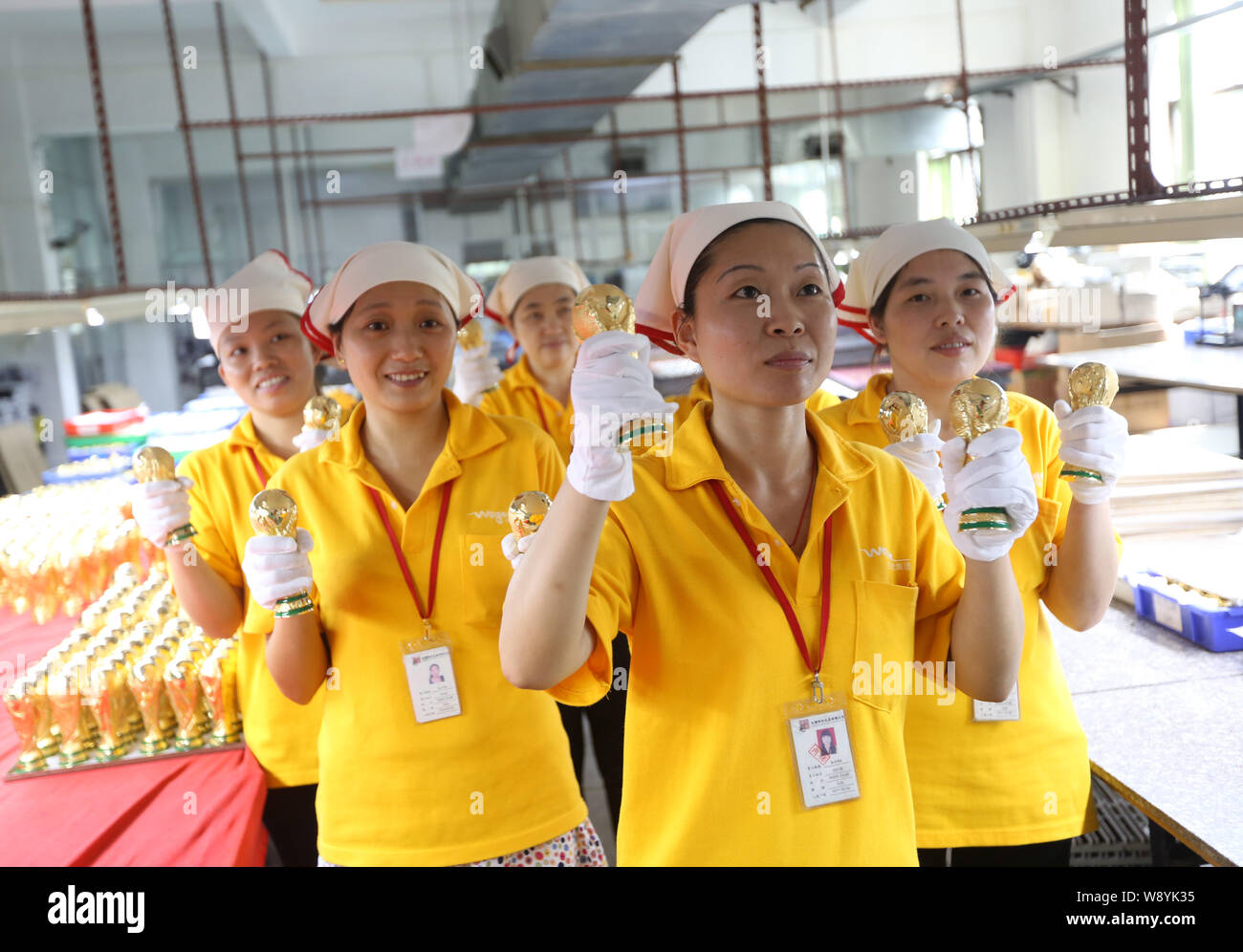 Female Chinese workers show newly-made miniature FIFA World Cup ...