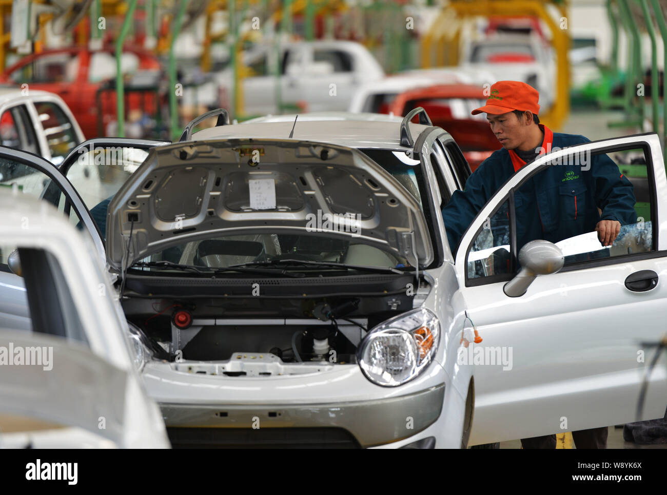 Chinese workers assemble electric cars on the assembly line at the auto ...