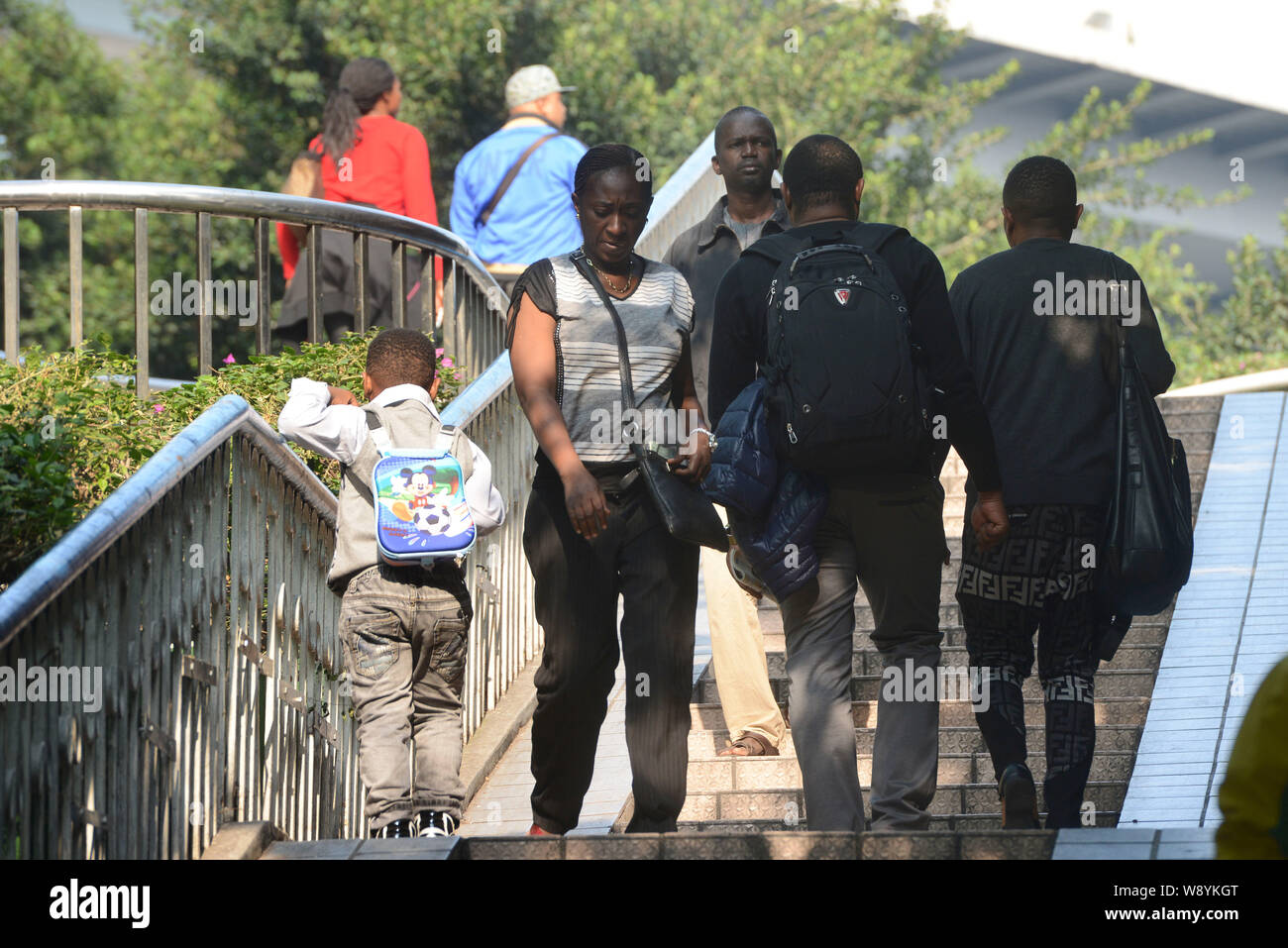 African people walk on a footbridge at Africa Town in Yuexiu district ...