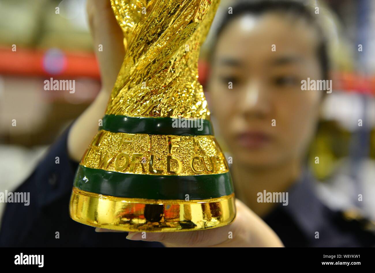 A Chinese customs officer checks a seized fake World Cup trophy at a ...