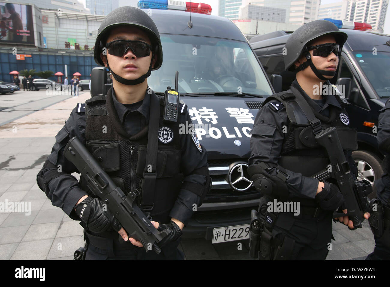 SWAT police officers armed with guns stand guard next to police ...
