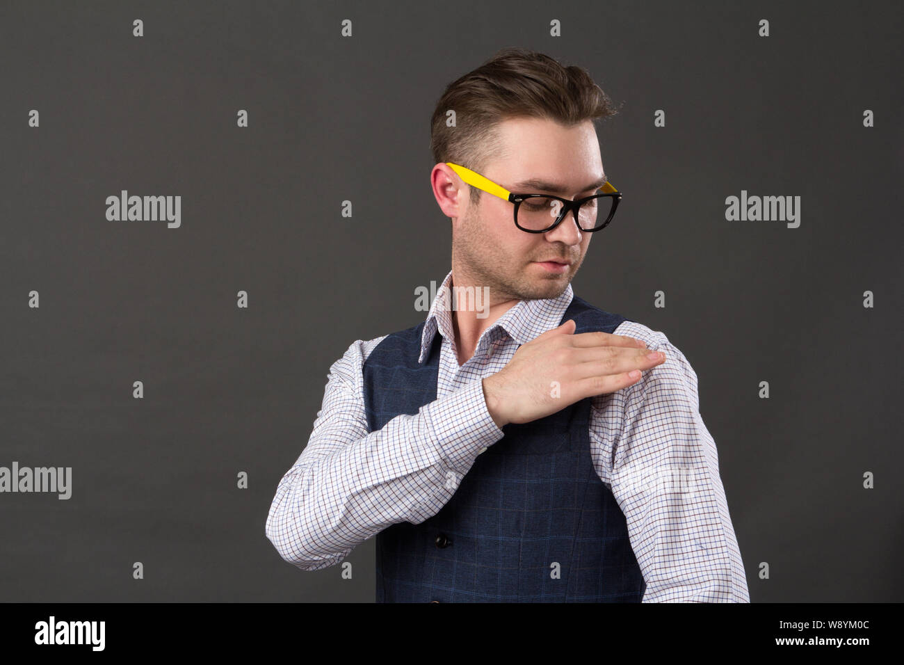 young guy shakes dust off shoulder, studio picture Stock Photo - Alamy