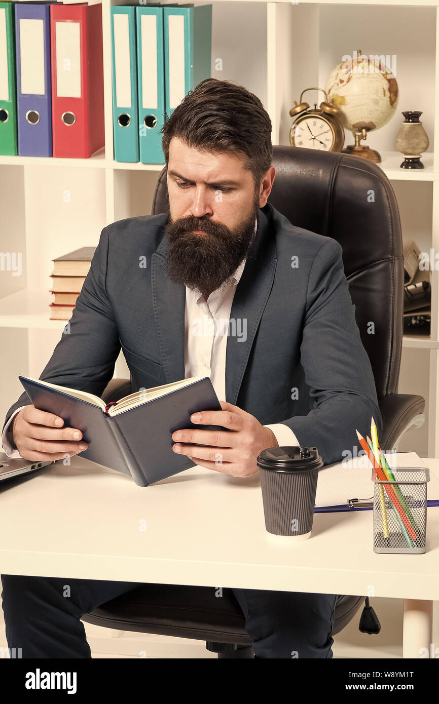 Reading authority business book. Man bearded hipster boss sit armchair ...