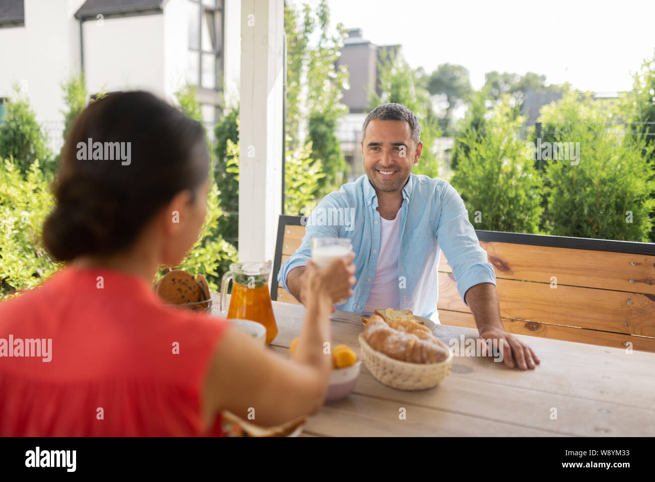 Husband smiling while having breakfast outside with wife Stock Photo ...