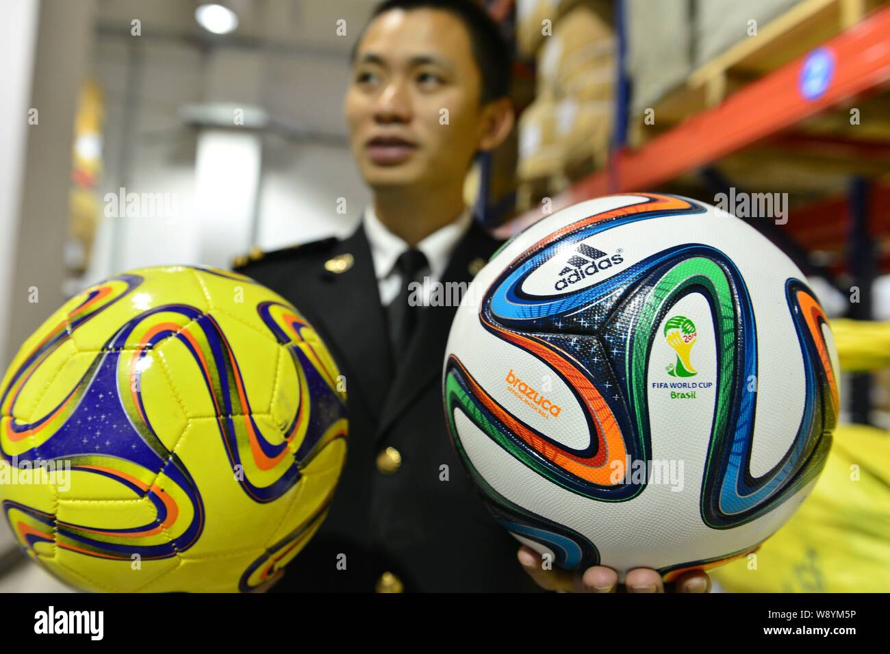 A Chinese customs officer shows seized fake World Cup footballs at a ...