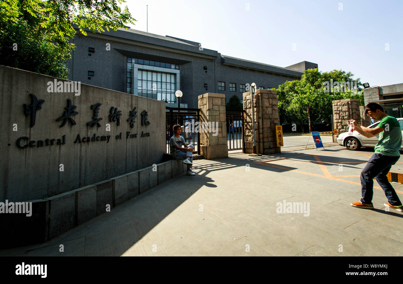A Chinese man poses for photos in front of the gate of Central Academy ...