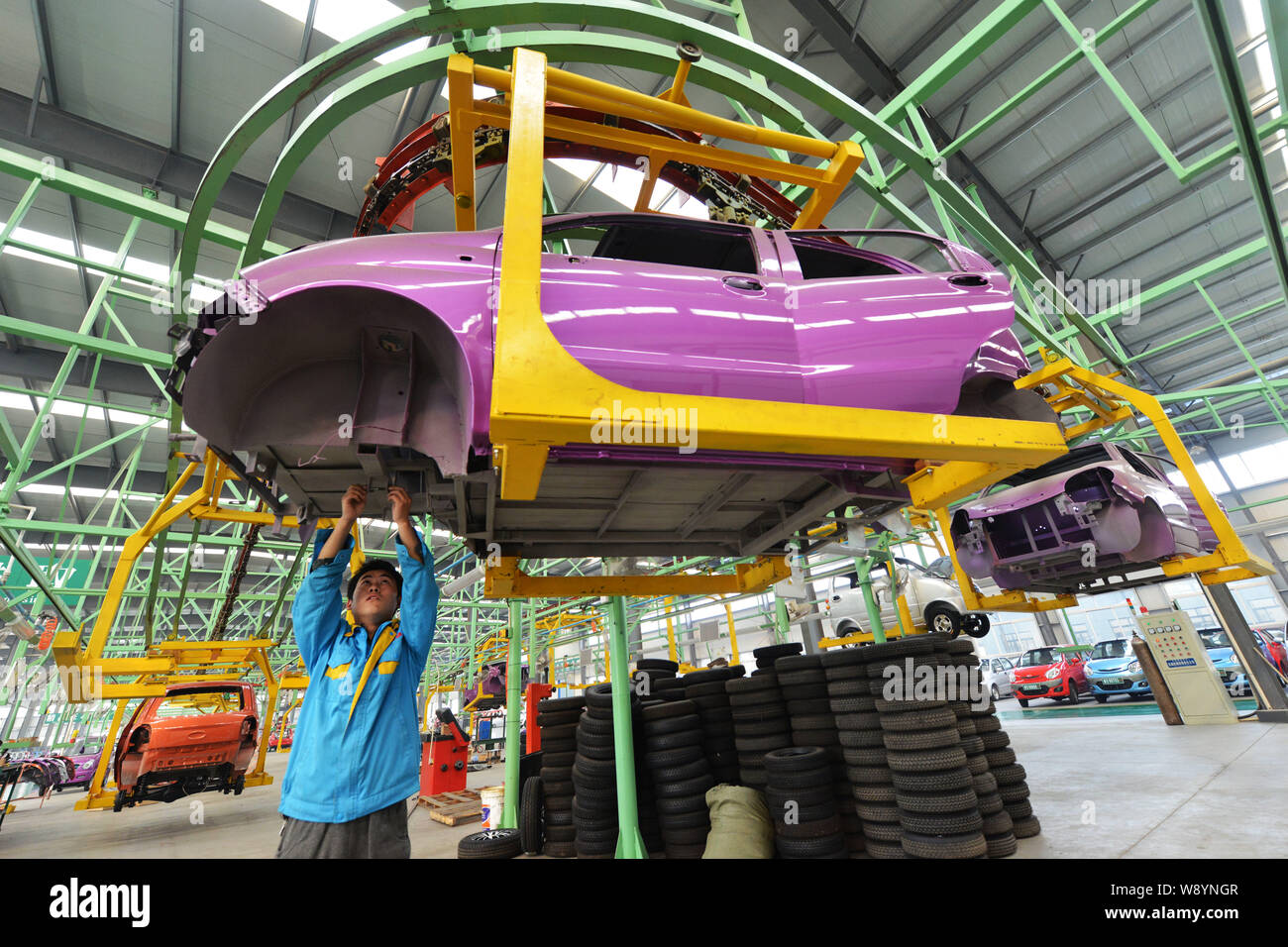 --FILE--A Chinese worker assembles an electric car on the assembly line ...