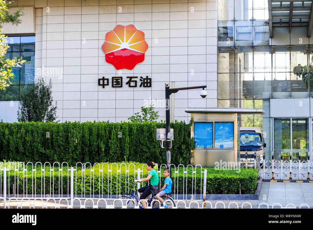 --FILE--Cyclists ride past the headquarters building of CNPC (China ...