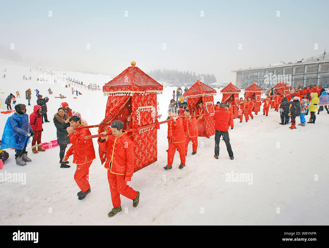 Chinese people shoulder palanquins to carry brides during a traditional ...