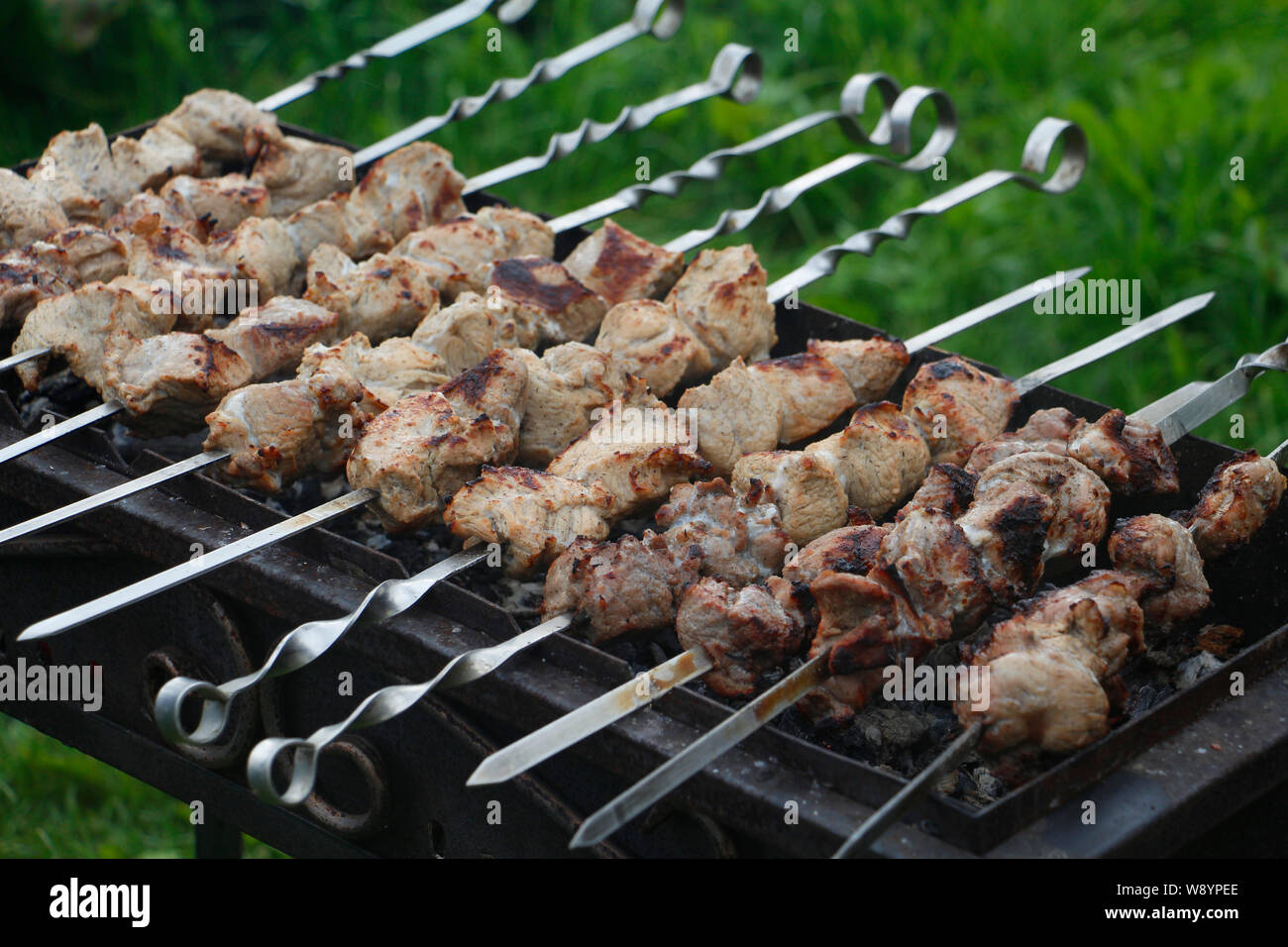 Cooking barbecue skewers. Marinated kebab is grilled on charcoal. Shish ...
