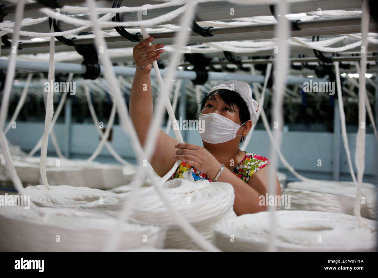 --FILE--A female Chinese worker handles production of yarn to be exported to South Korea at a ...