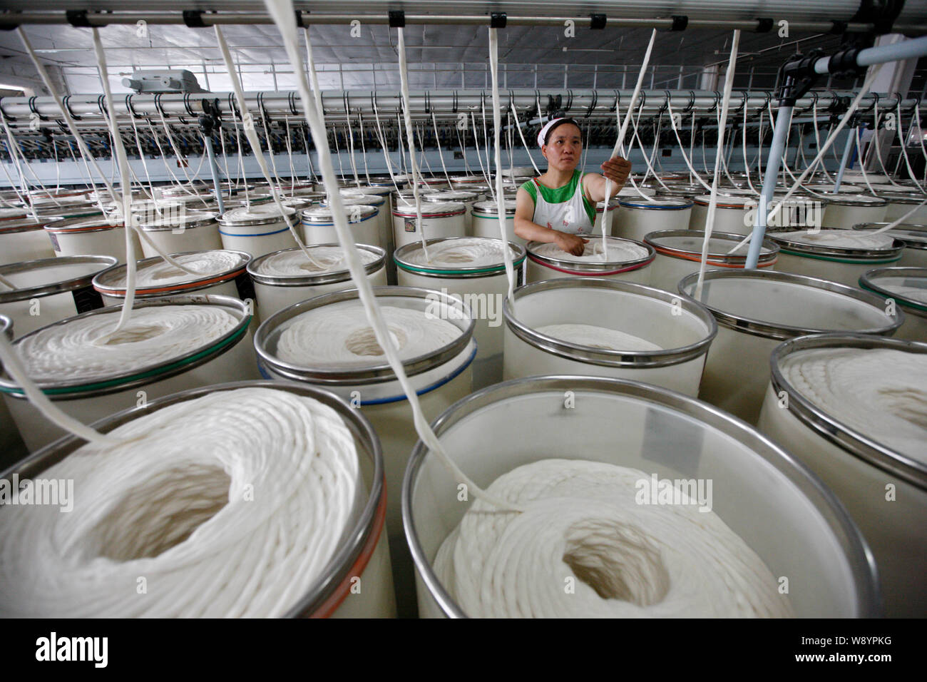 --FILE--A female Chinese worker handles production of yarn to be exported to Europe at a textile ...
