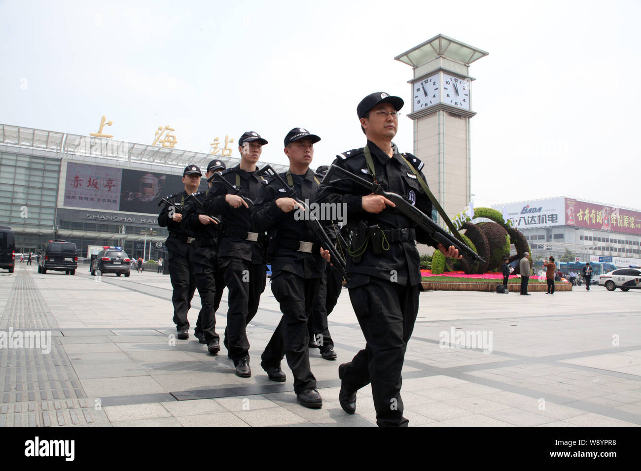 Police officers armed with guns patrol at the square of the Shanghai ...