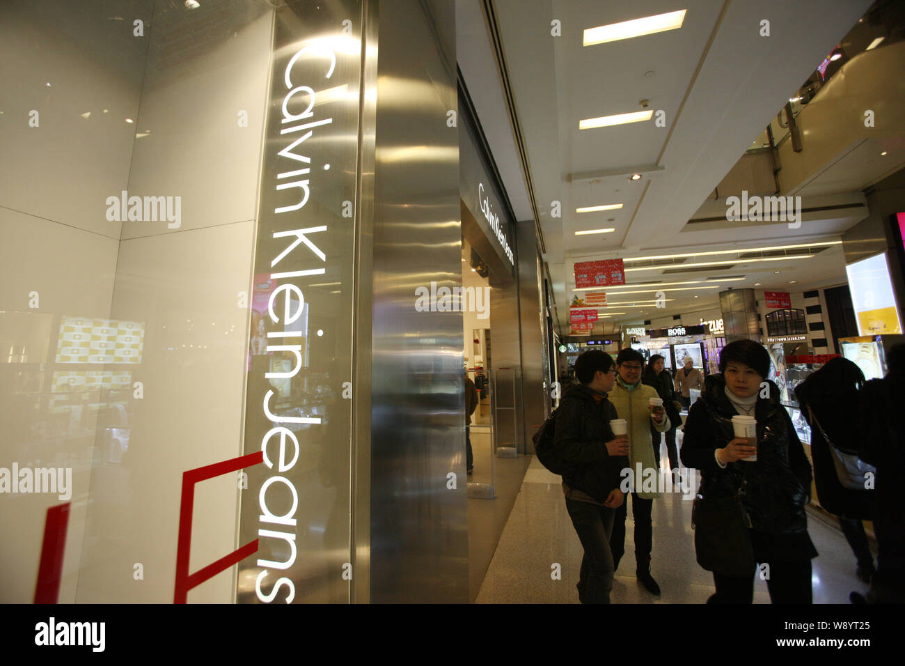 --FILE--Customers walk past a Calvin Klein Jeans (CK Jeans) boutique at ...
