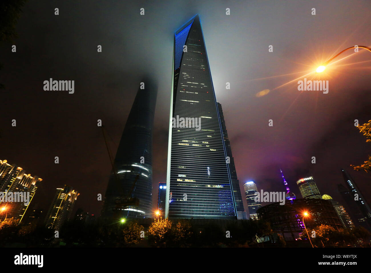 Night view of the Shanghai Tower under construction, tallest left, the ...