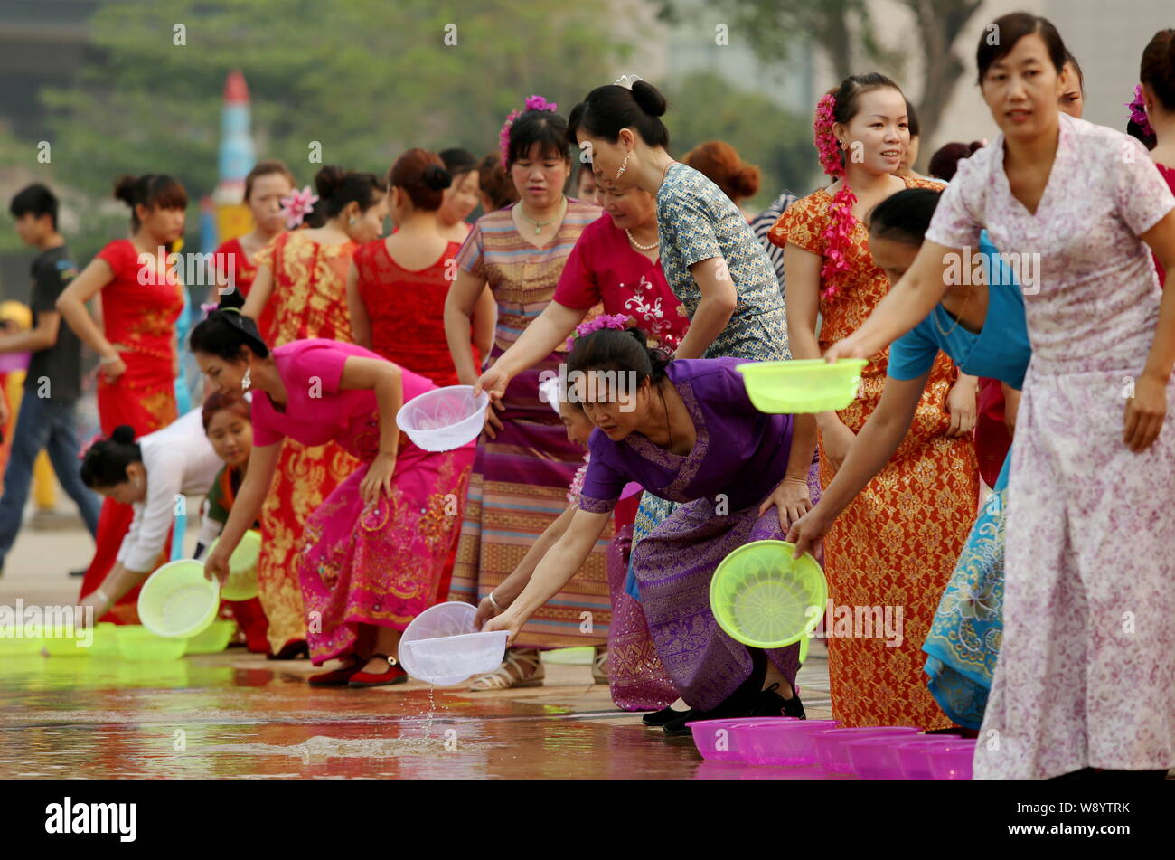 Chinese women of Dai ethnic minority pour water on the ground to ...