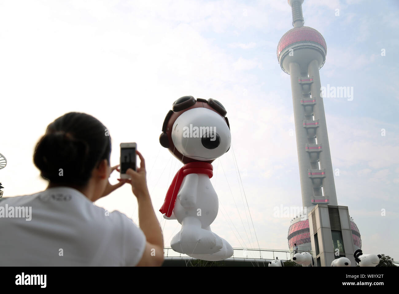 A visitor takes a photo of an 8-meter-high Snoopy balloon at Shanghai ...