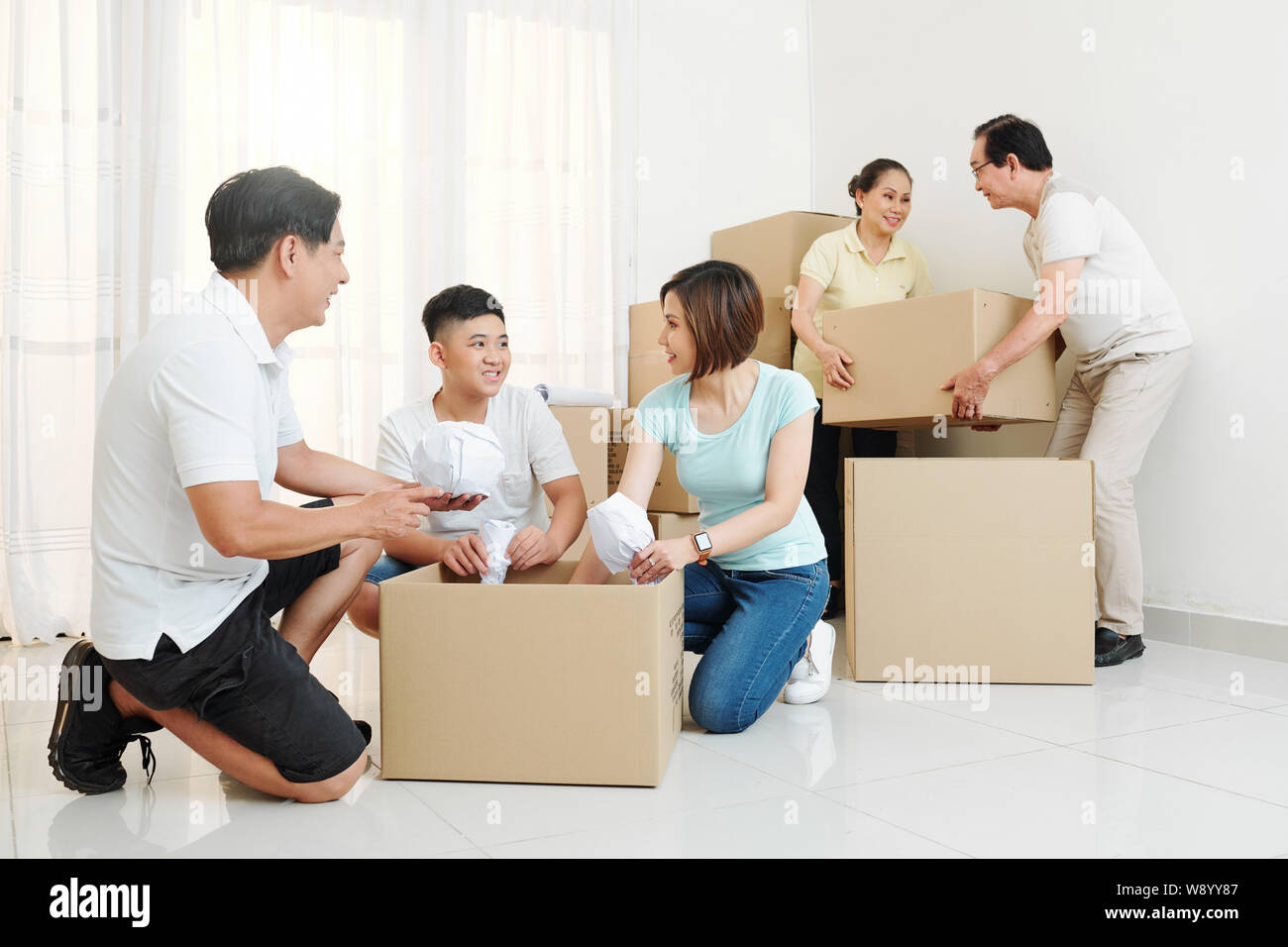 Family packing things and moving out Stock Photo - Alamy