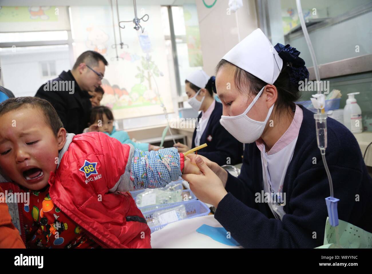 --FILE--A Chinese nurse wearing a surgical face mask gives an injection ...