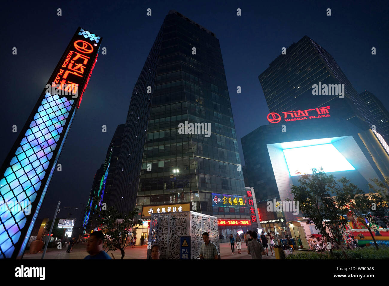 --FILE--Pedestrians walk past a Wanda Plaza of Dalian Wanda Commercial ...