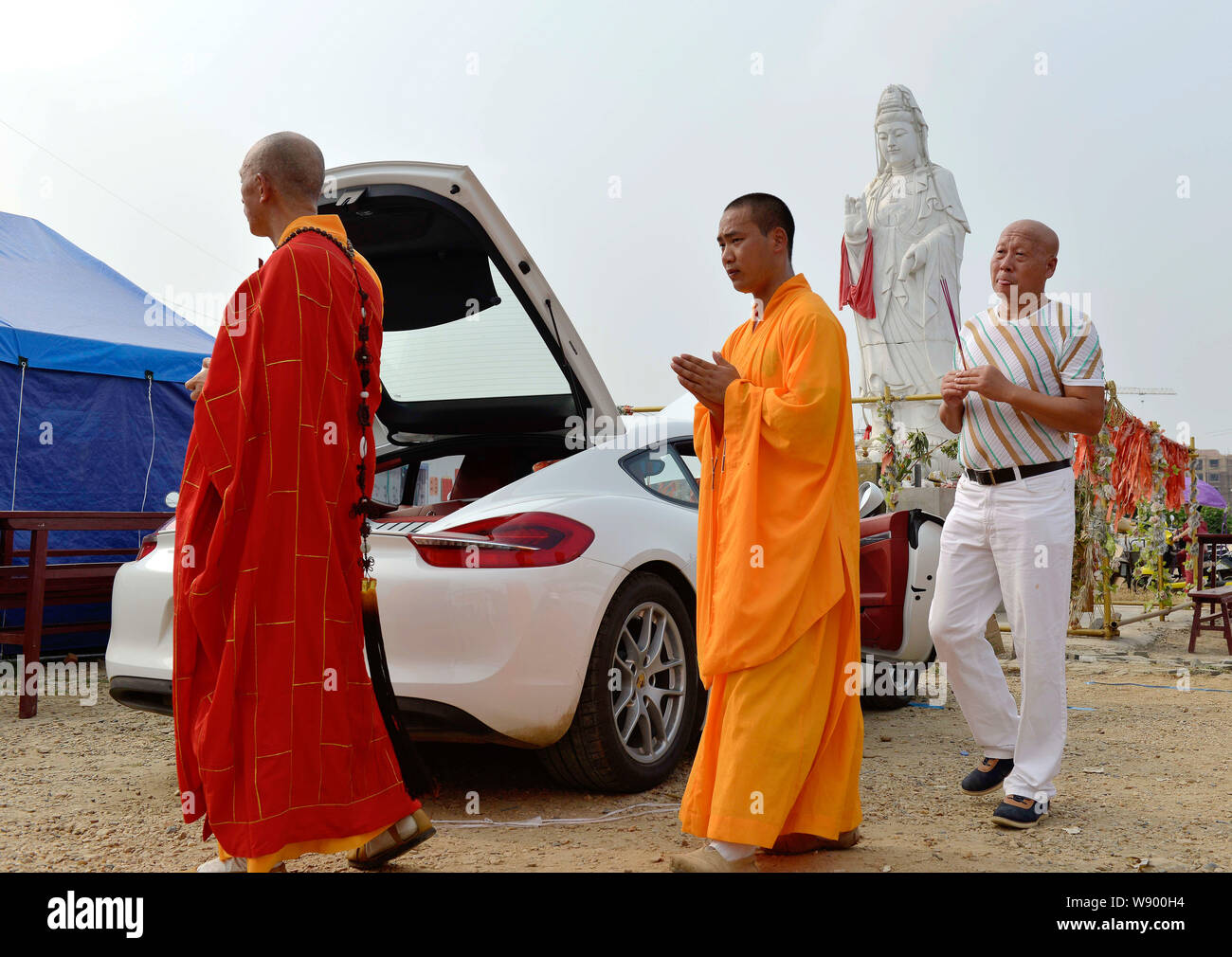 Chinese Buddhist monks bless a Porsche sports car during a great dharma ...