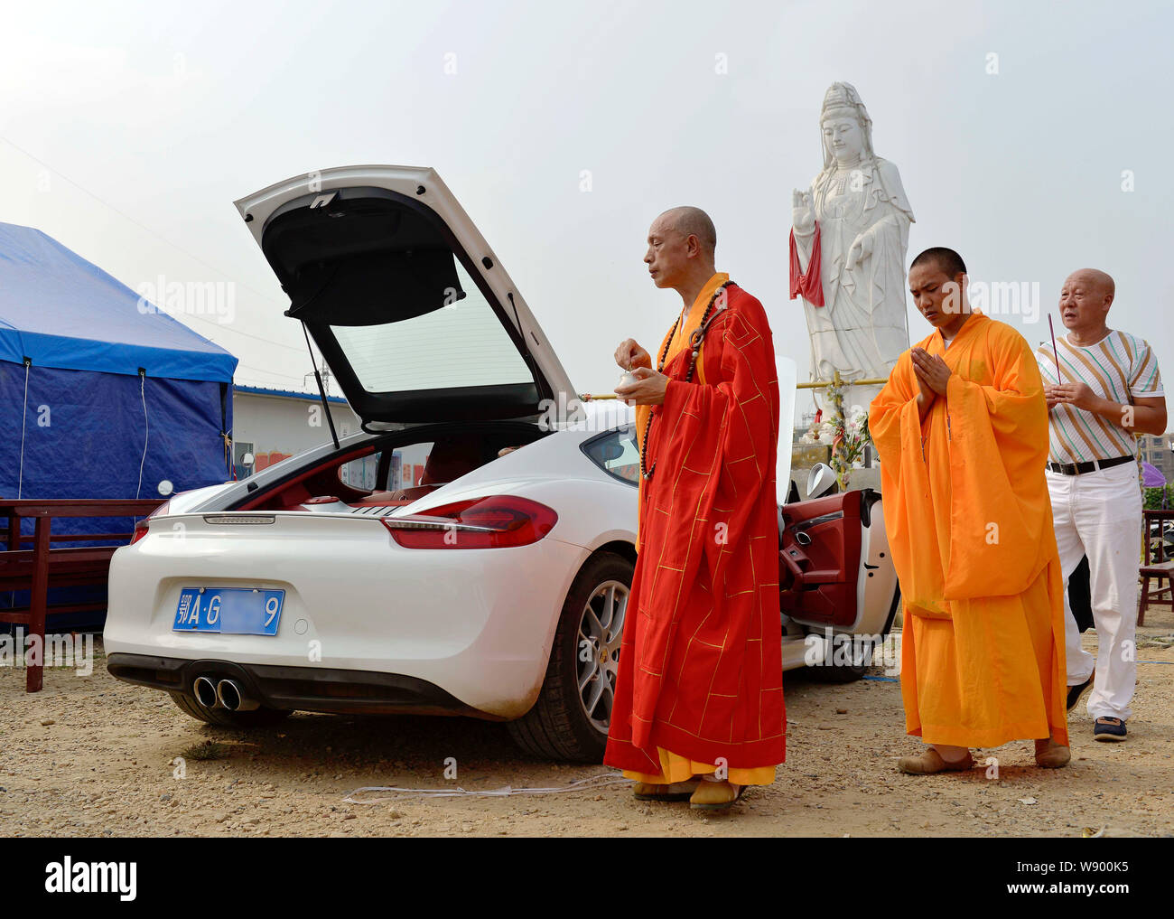 Chinese Buddhist monks bless a Porsche sports car during a great dharma ...