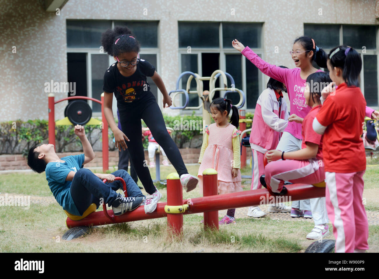 Chinese African girl Xiao Xiao, second left, plays games with her ...