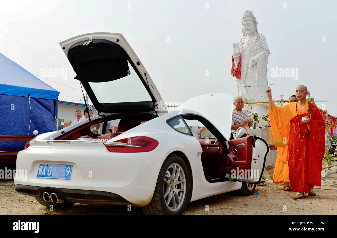 Chinese Buddhist monks bless a Porsche sports car during a great dharma ...