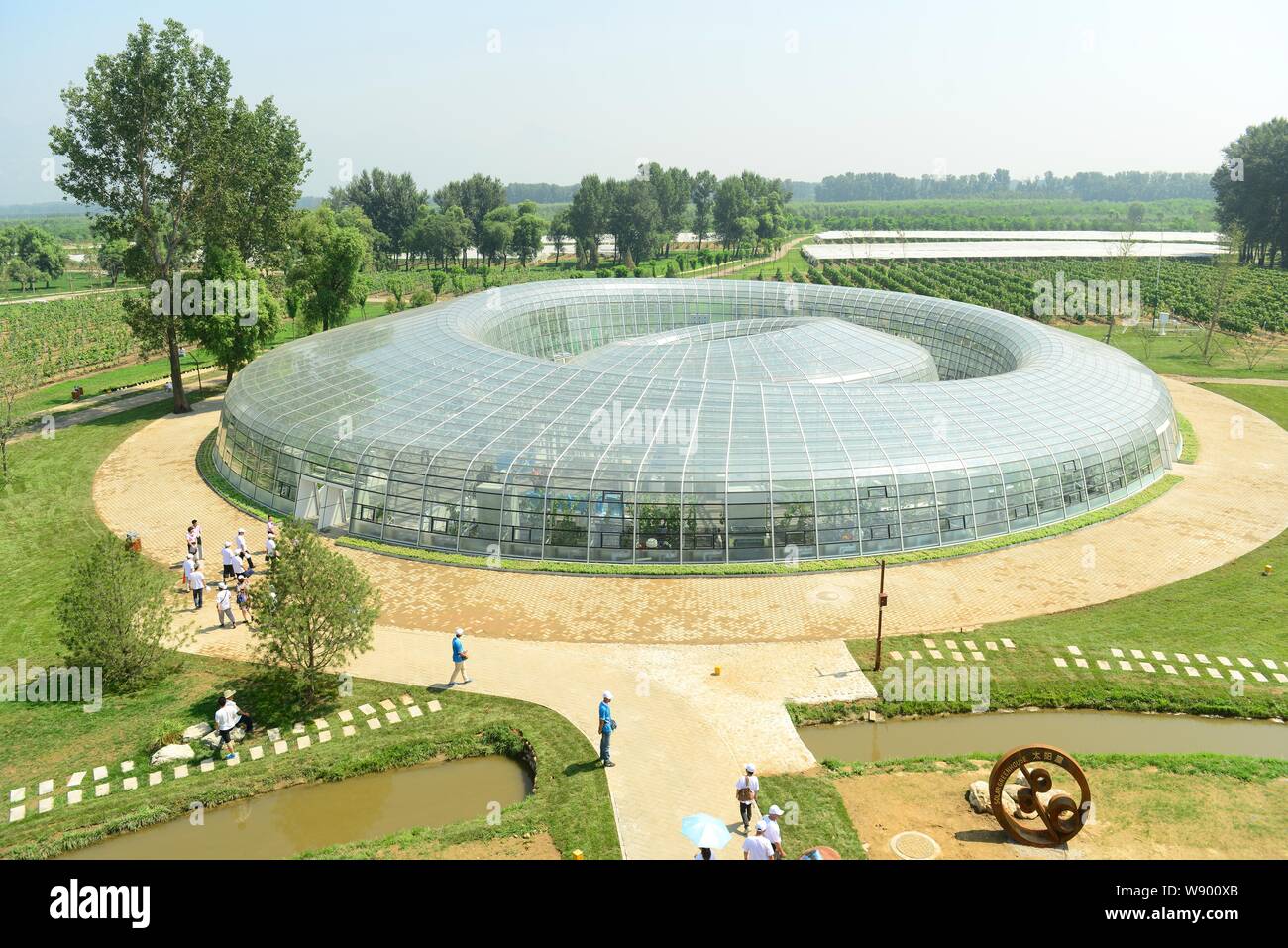 --FILE--Visitors walk past a greenhouse at the International Grape ...