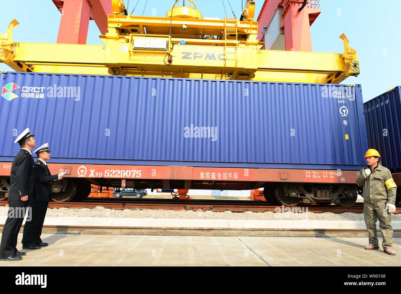 Chinese customs officers verify a container being loaded onto the first ...