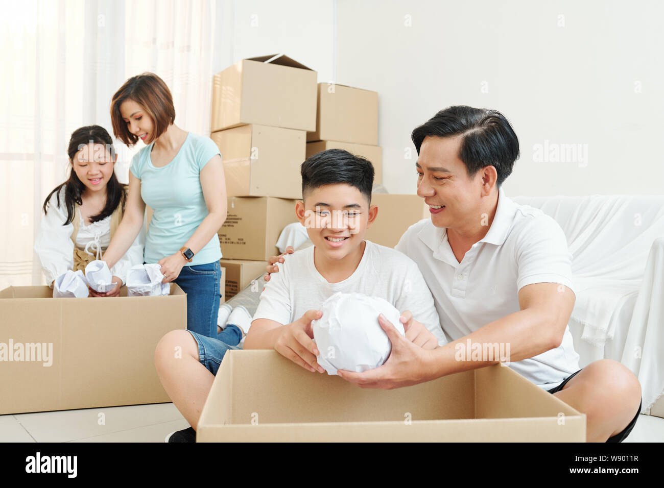 Family unpacking belongings Stock Photo - Alamy