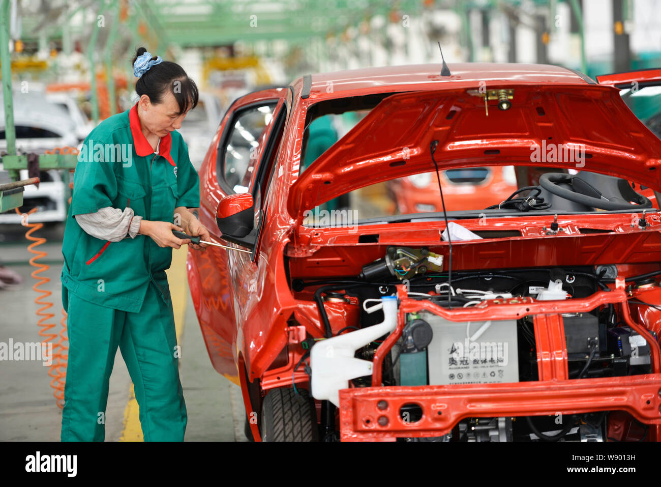 --FILE--A female Chinese worker assembles an electric car on the ...