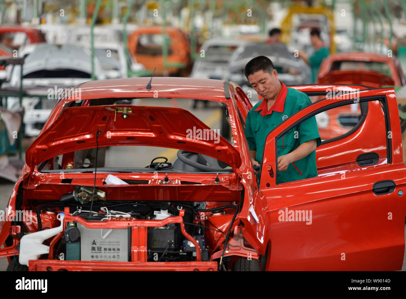 --FILE--A Chinese worker assembles an electric car on the assembly line ...