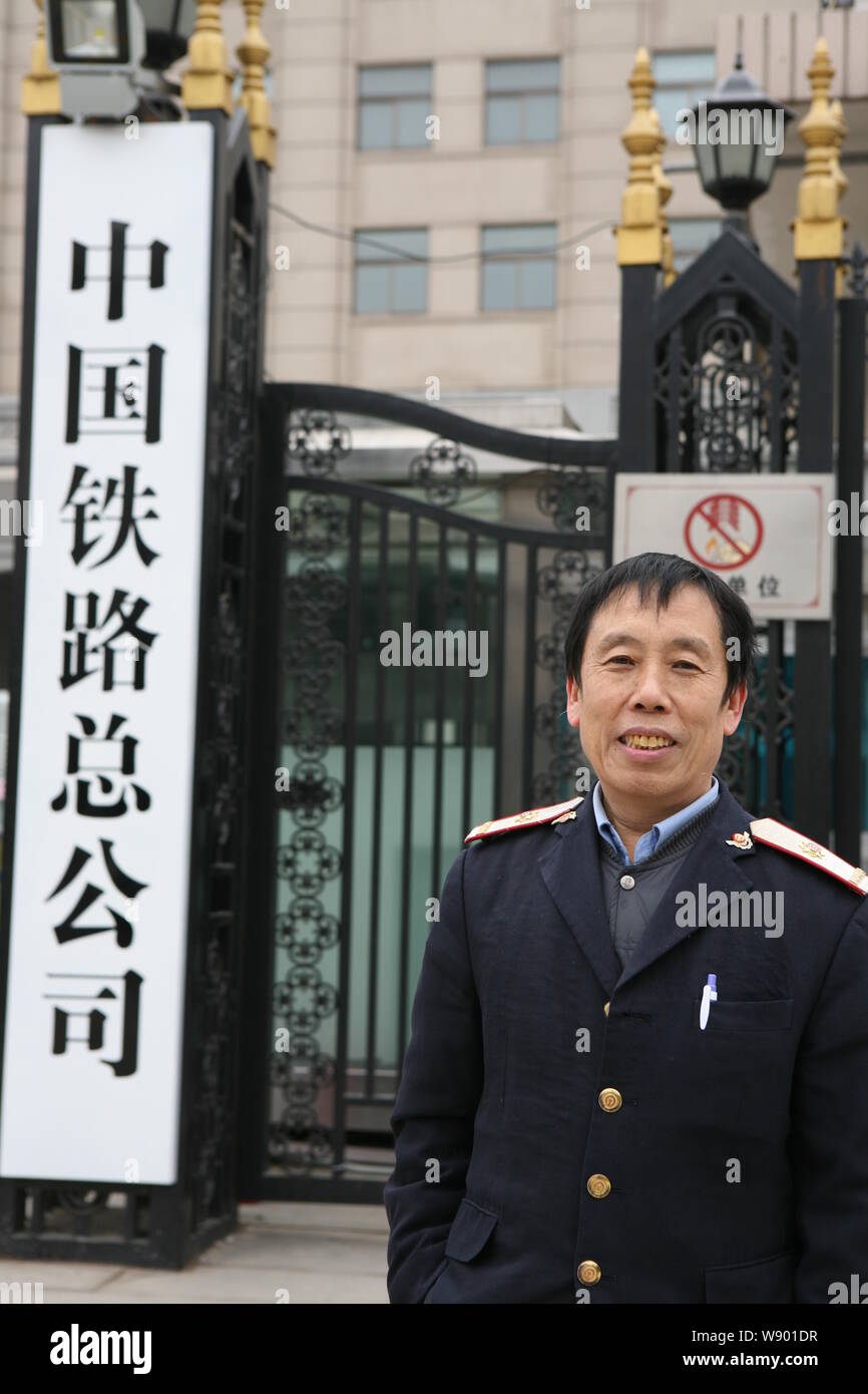 --FILE--A retired Chinese train conductor poses for photos at the gate ...