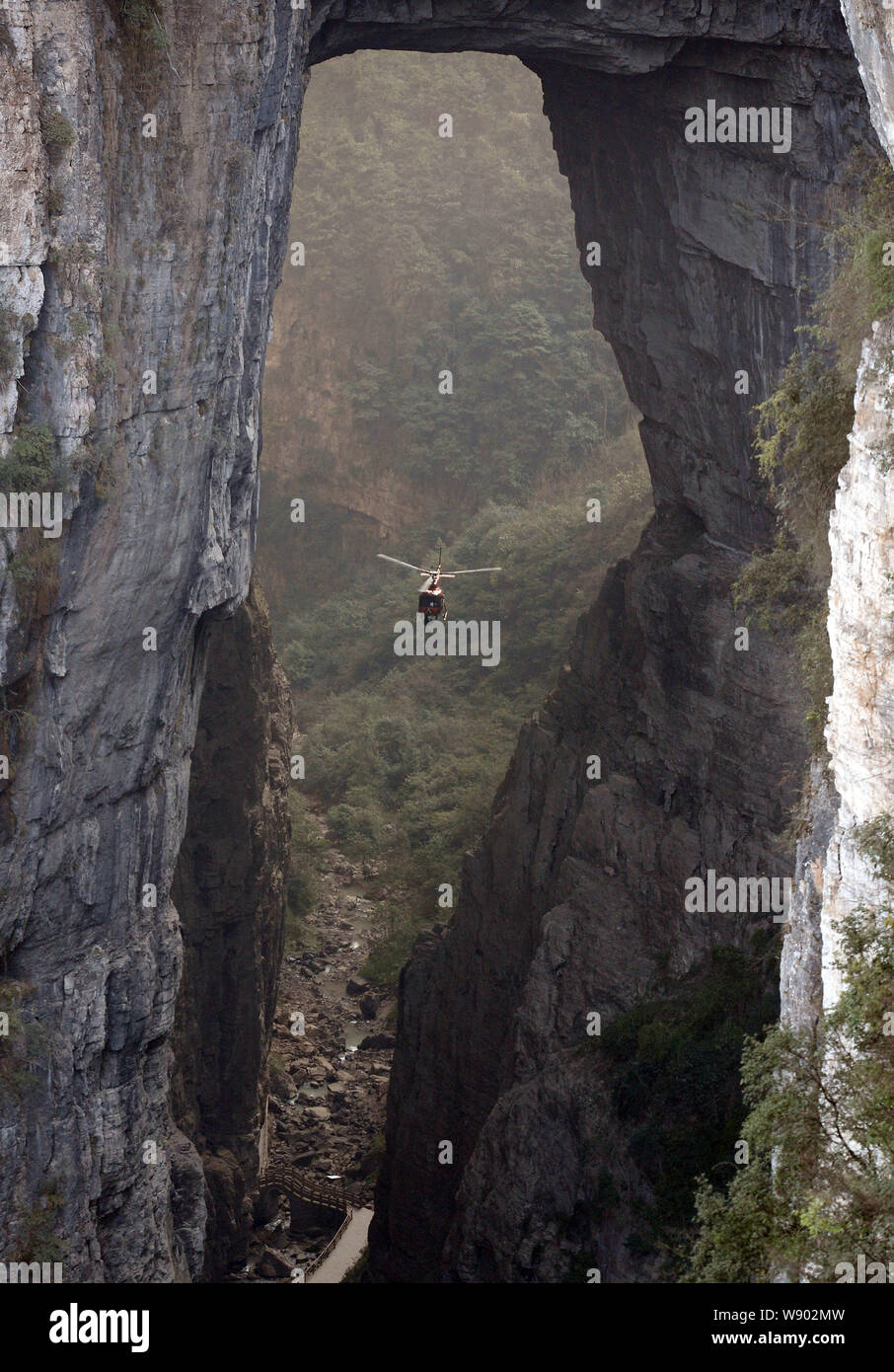 A helicopter flies through a mountain cave to film scenes during a ...