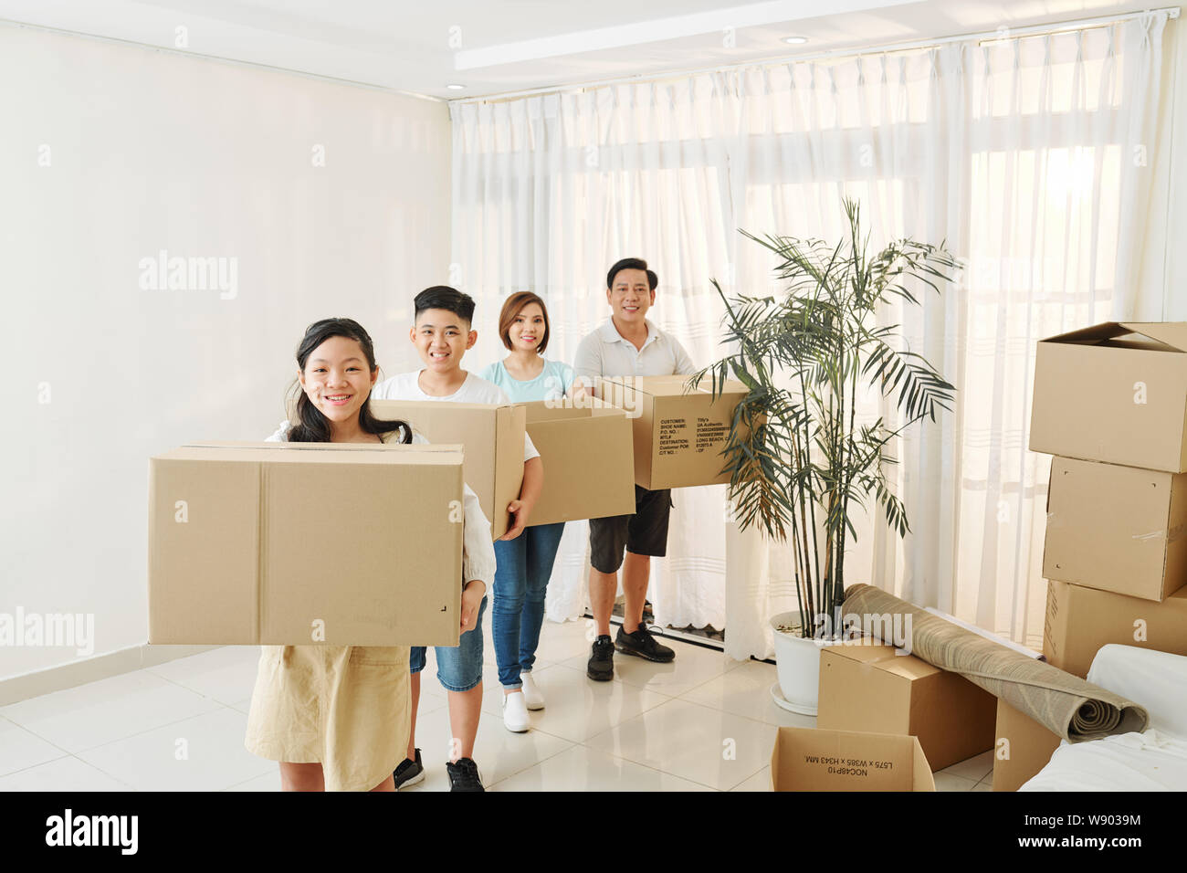 Happy family with cardboard boxes Stock Photo - Alamy