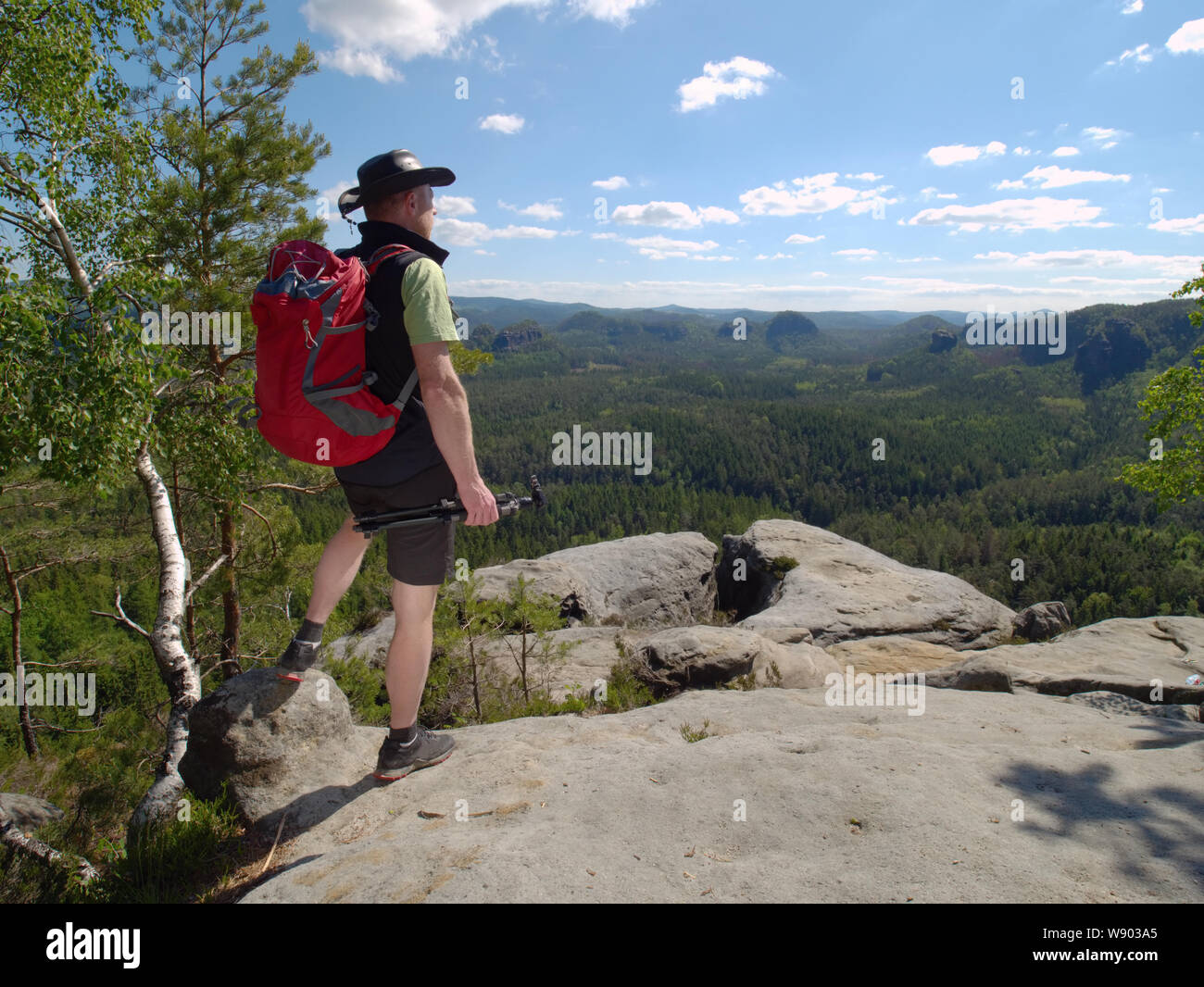 Tourist watch land from mountain top. Man wear big backpack against sun ...