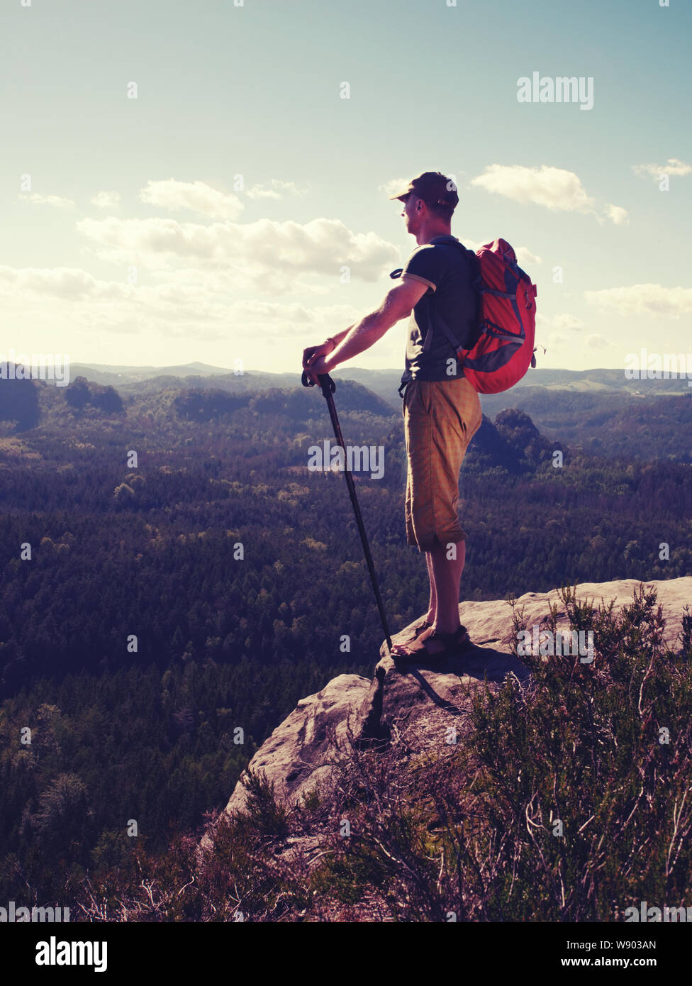 Tourist watch land from mountain top. Man wear big backpack against sun ...