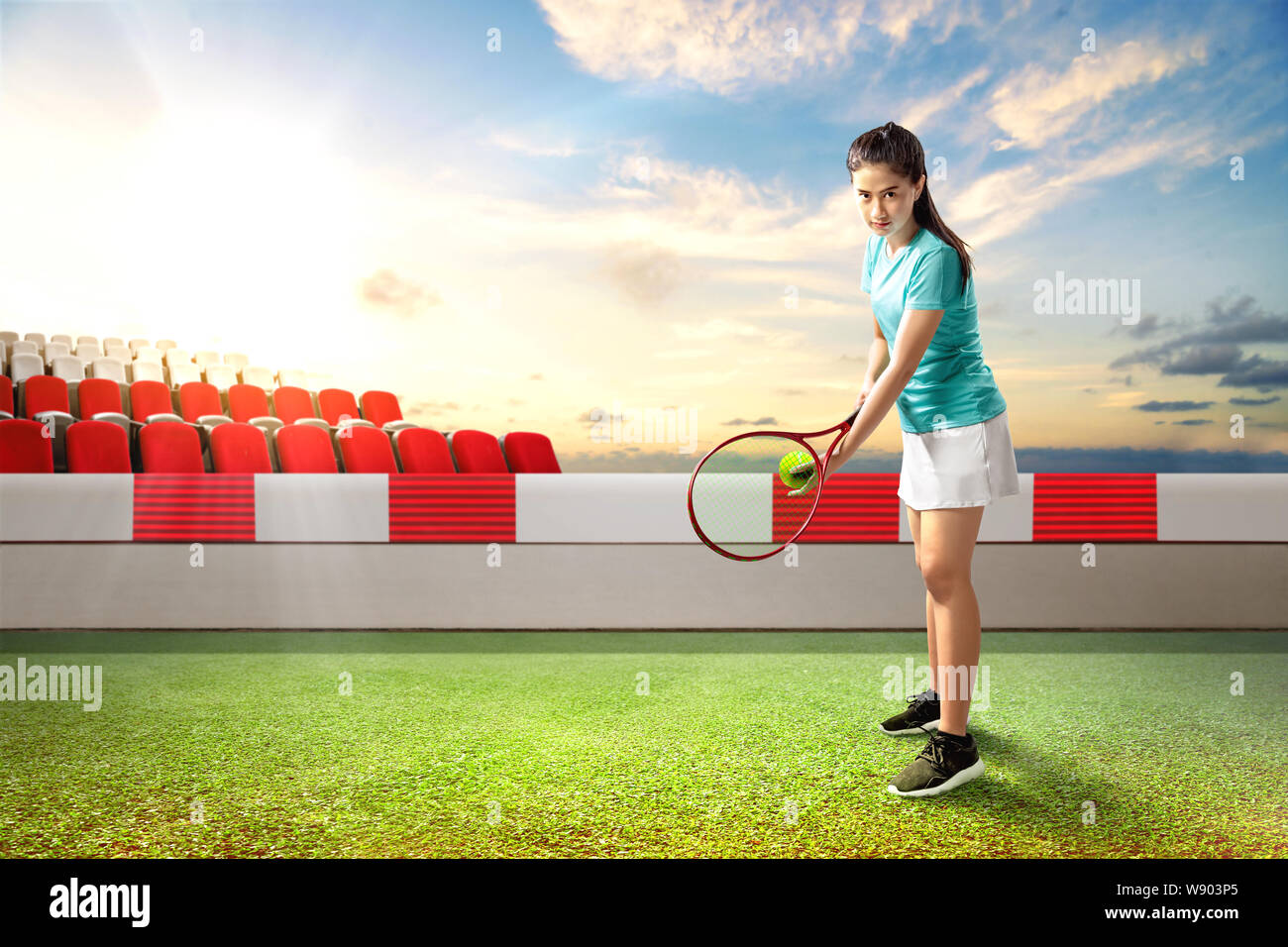 Asian woman with a tennis racket and ball in her hands ready in serve ...