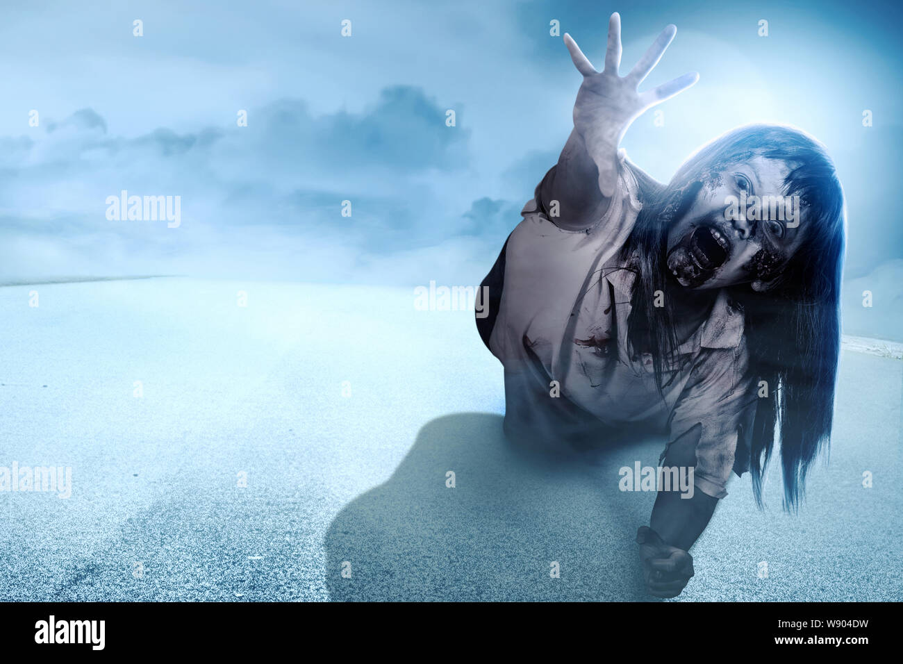 Scary zombies with blood and wound on his body crawling on the asphalt ...