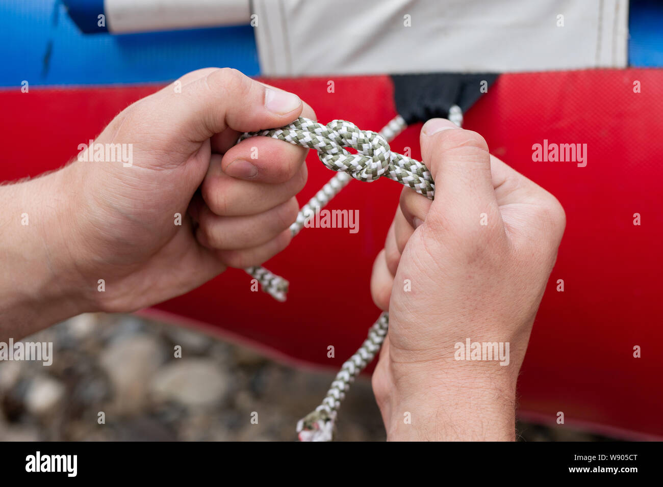 male hands tie a knot on a rope aboard a boat, ship or yacht Stock ...