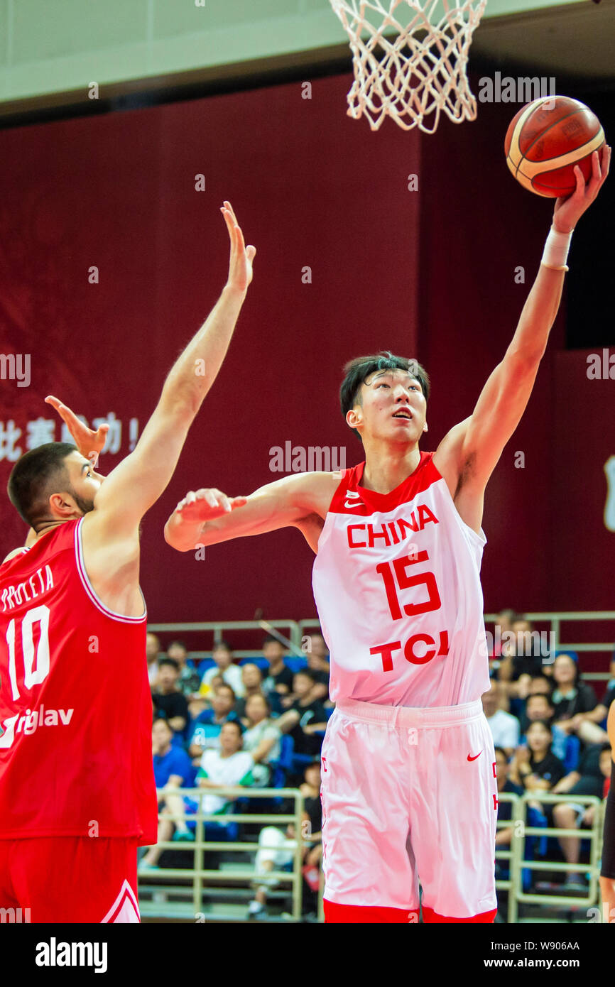 Zhou Qi, a professional Chinese basketball player, right, jumps for a ...