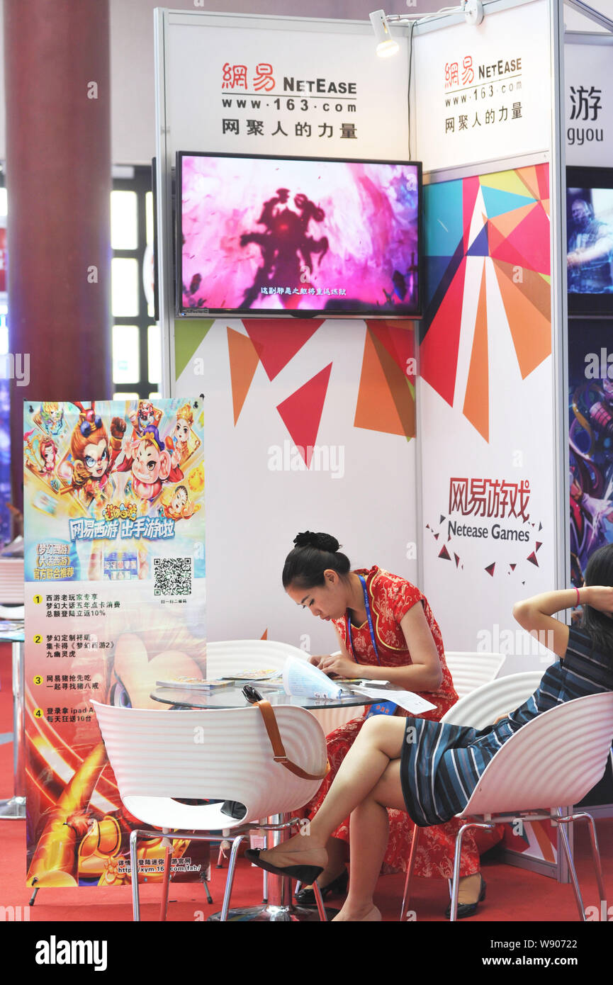 --FILE--Chinese employees are seen at the stand of NetEase, also known ...