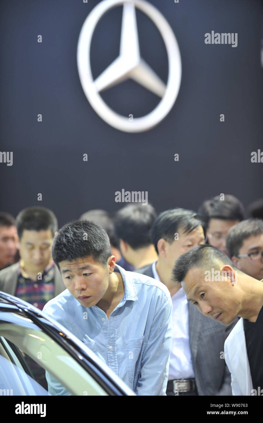 Visitors look at a car at the stand of Mercedes-Benz during the 13th ...
